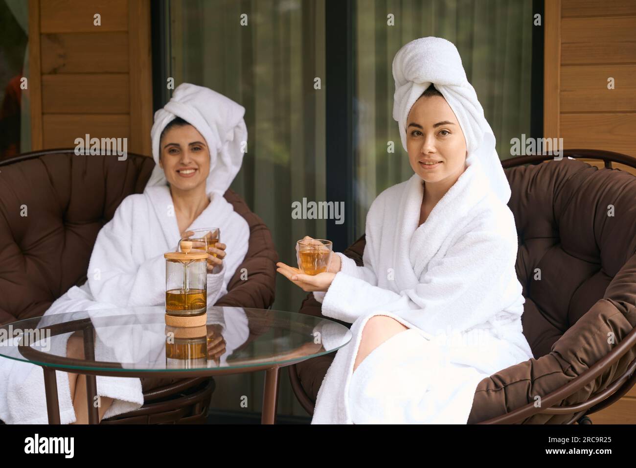 Smiling women in white robes after spa treatments Stock Photo - Alamy
