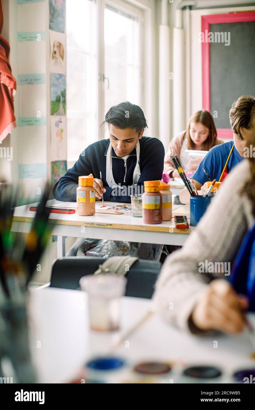 Teenage student doing painting during art class at high school Stock ...