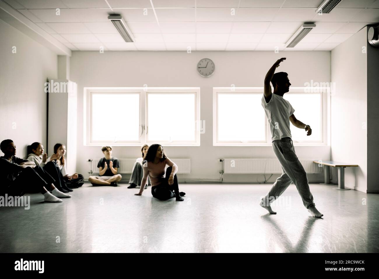 Male and female students looking at boy dancing in studio at high school Stock Photo - Alamy