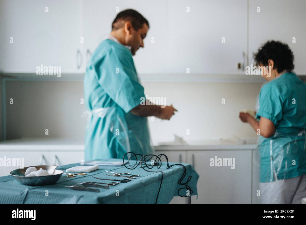 Male and female surgeons getting ready for surgery in hospital Stock ...