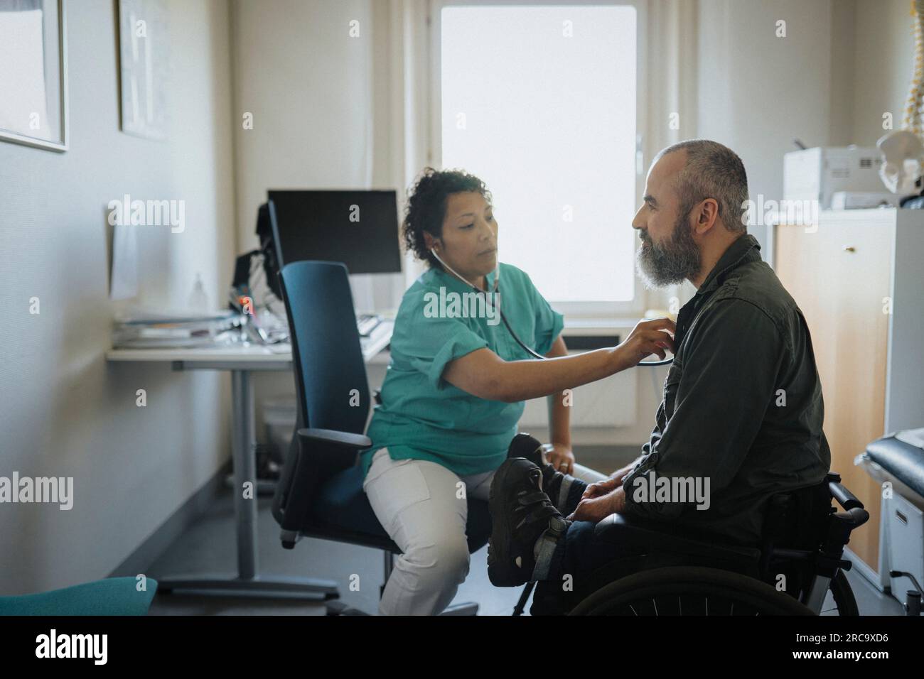 Female doctor examining mature man with disability in hospital Stock ...