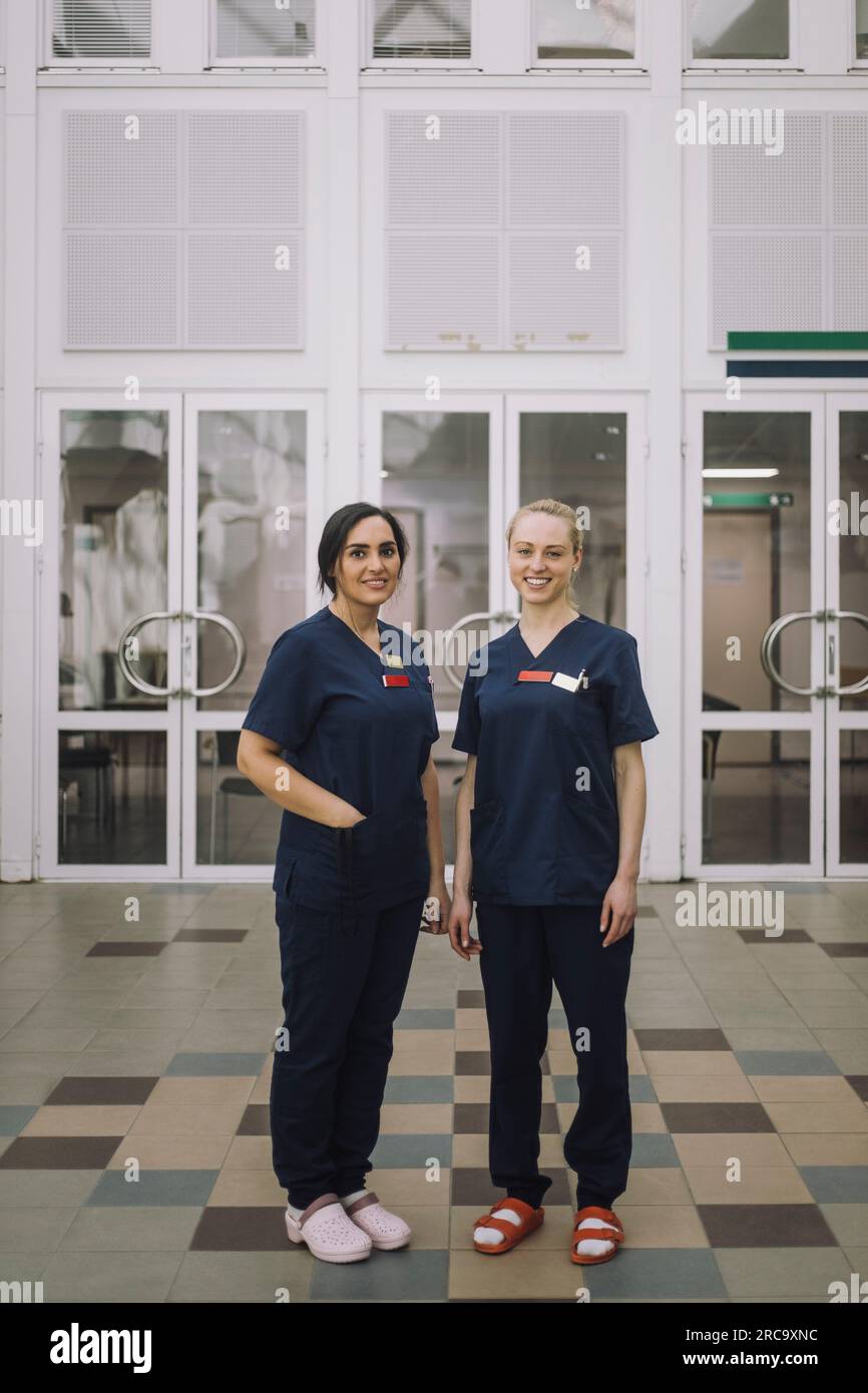Portrait of smiling healthcare female staff standing in front of ...