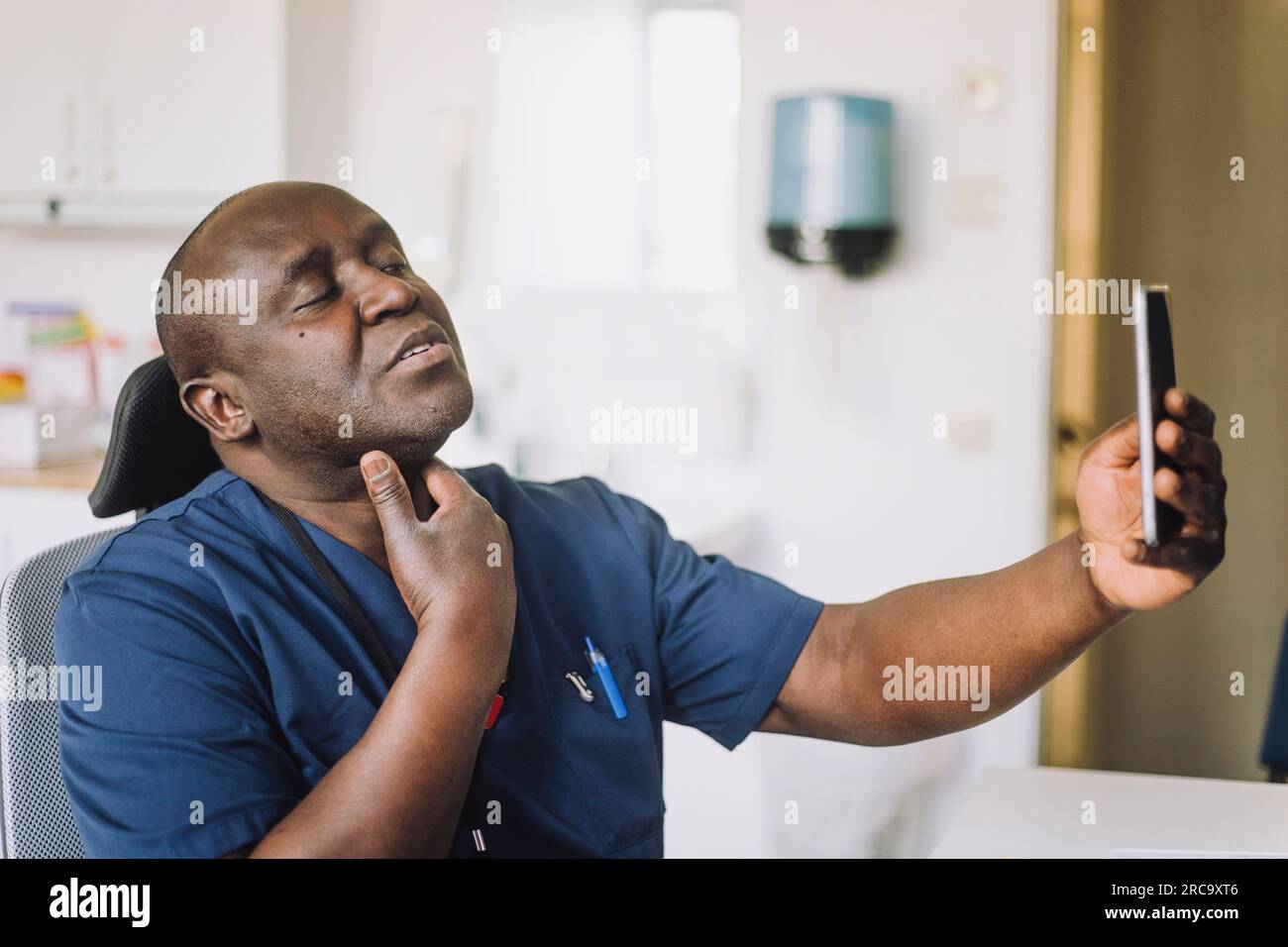 Male medical staff consulting patient over video call through smart ...