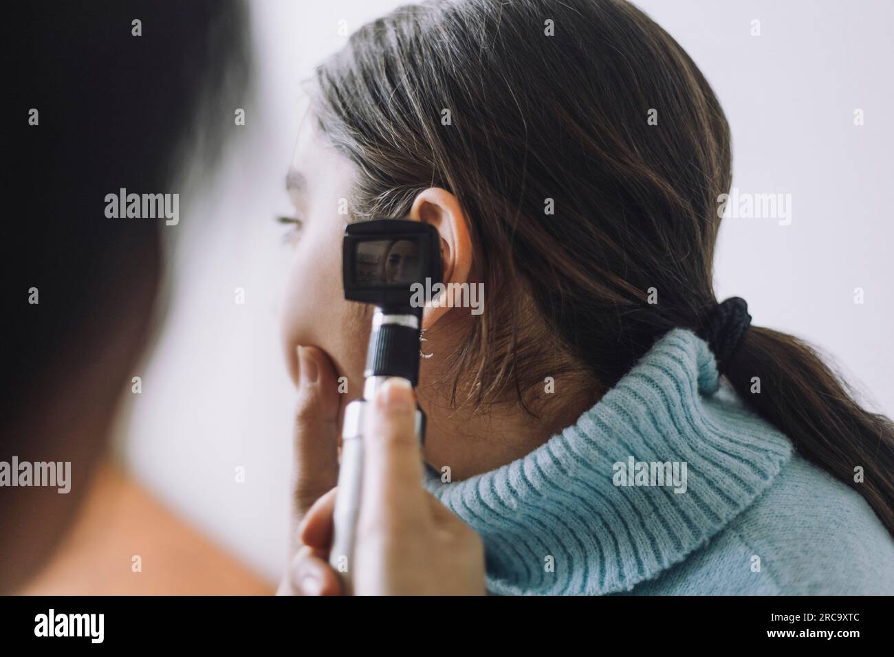 Doctor examining patient's ear using Otoscope at hospital Stock Photo ...