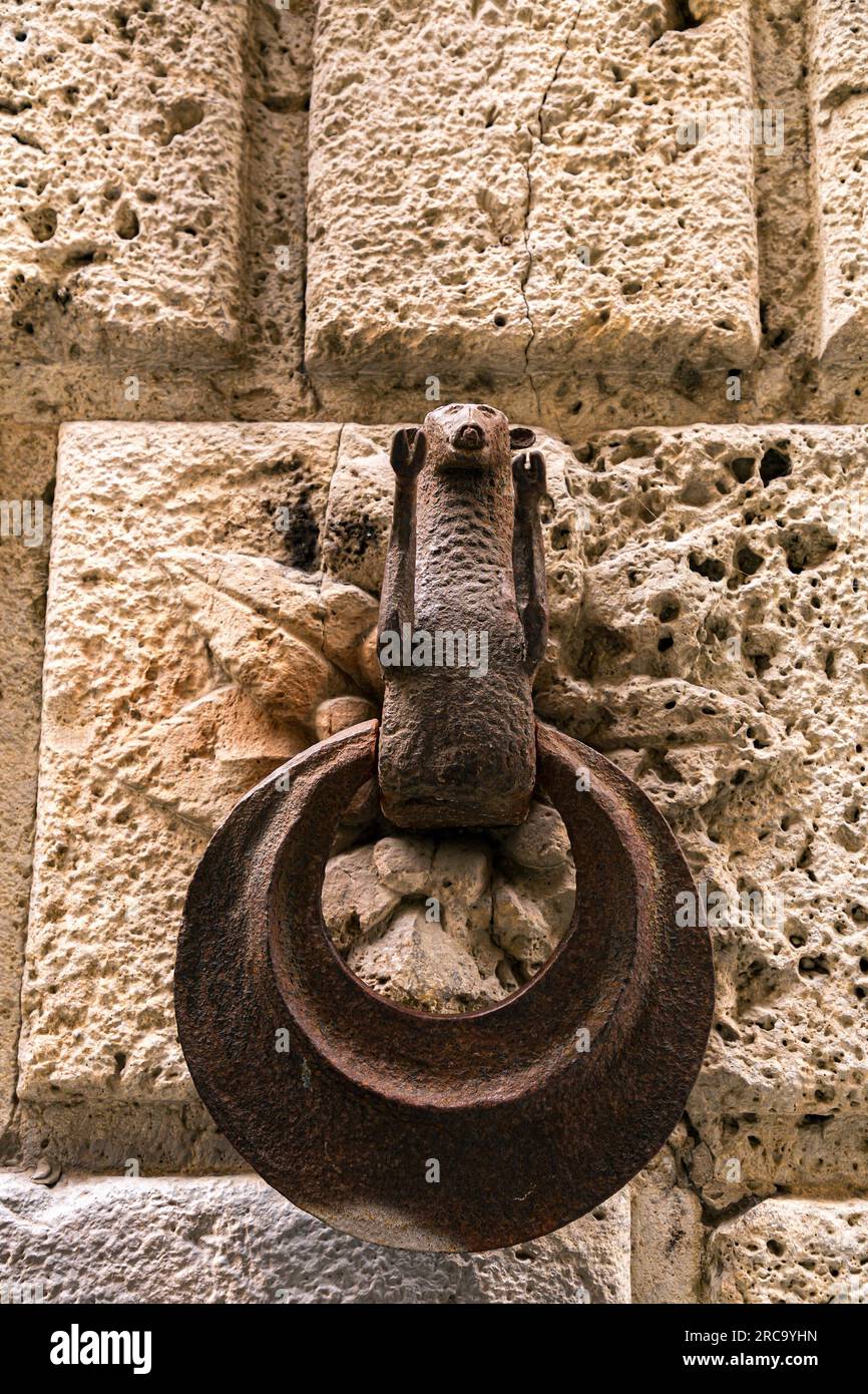 Rusty and weathered metal horse hitching ring on a wall of an old ...