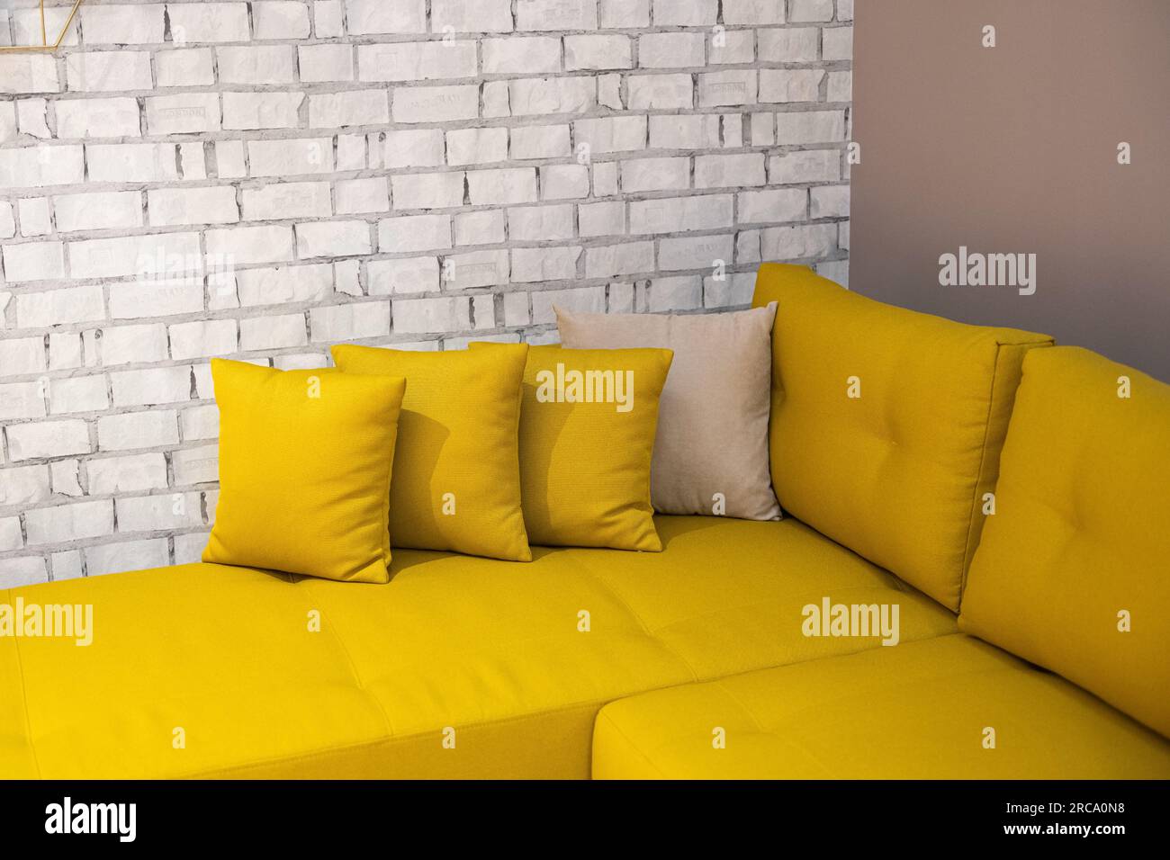interior of a corner yellow sofa with pillows Stock Photo - Alamy