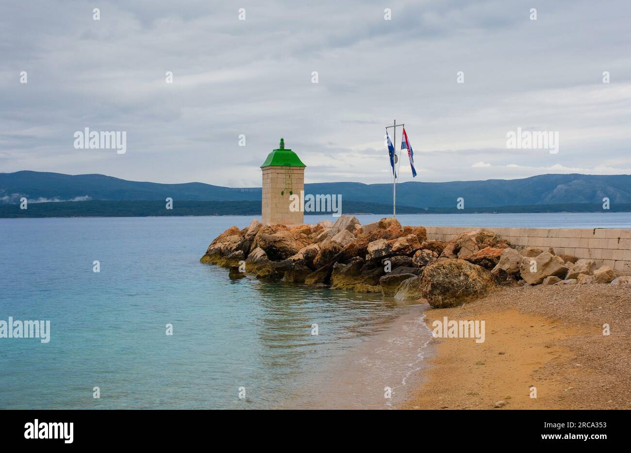 The pier and harbour lighthouse on the waterfront of Bol town on Brac ...