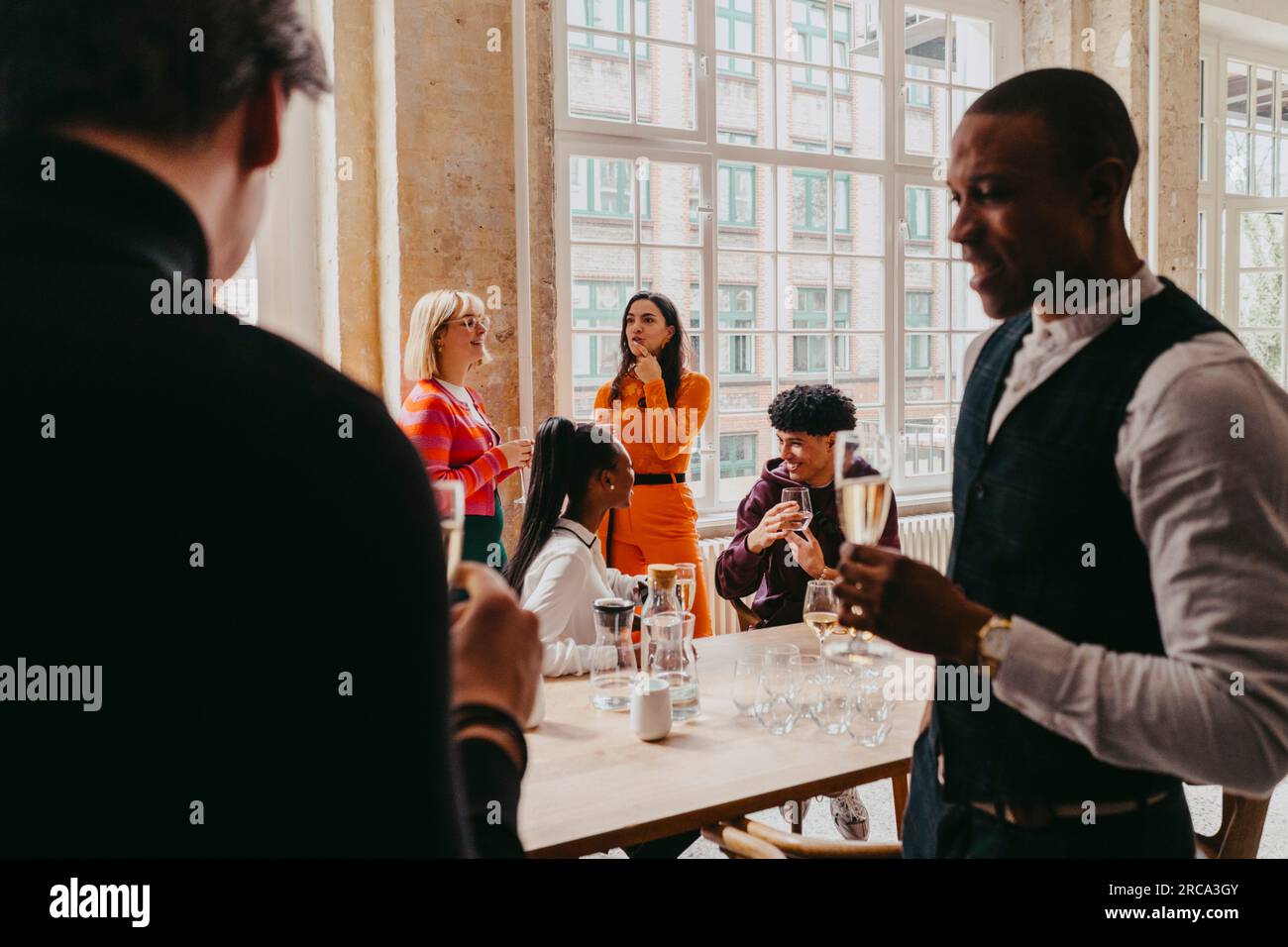Male and female business colleagues having drinks during event at ...