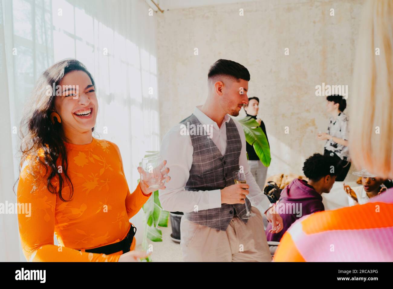 Happy businesswoman laughing while standing with male colleague during ...