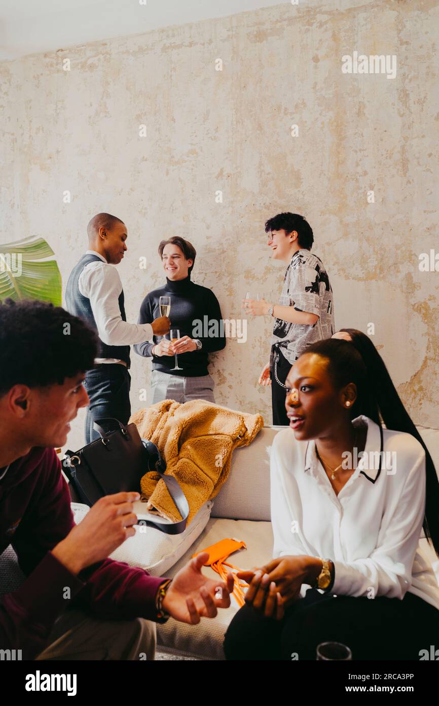 Business colleagues communicating with each other during networking ...