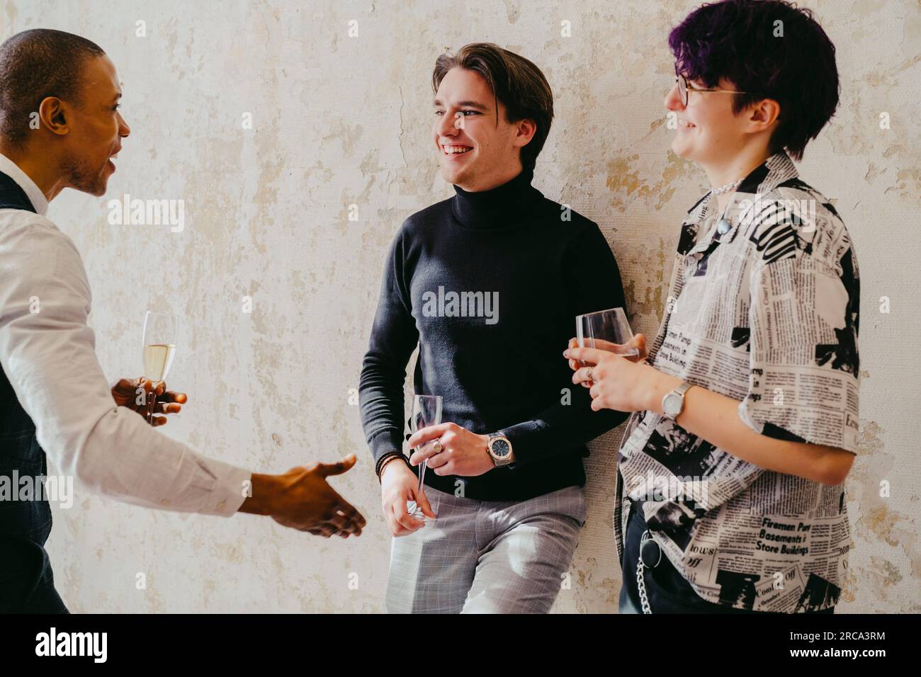 Smiling business colleagues enjoying and having drinks during event at ...