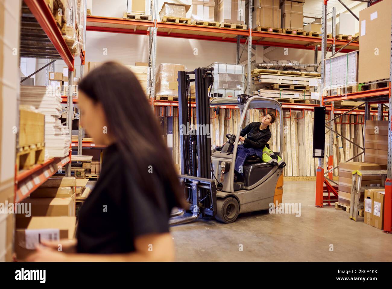 Female forklift operator looking up while working in lumber industry ...