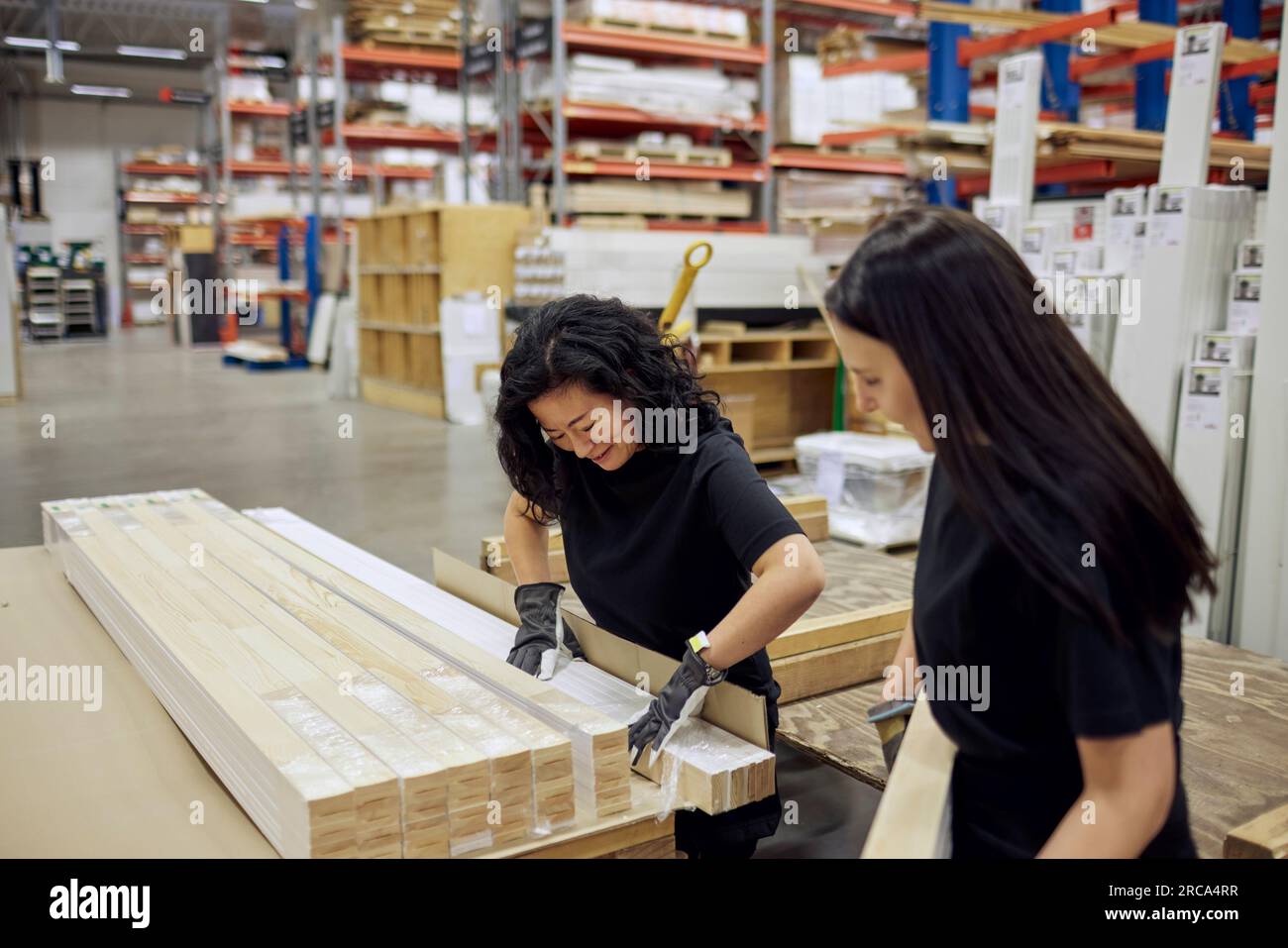 Multiracial female coworkers arranging planks in lumber industry Stock ...