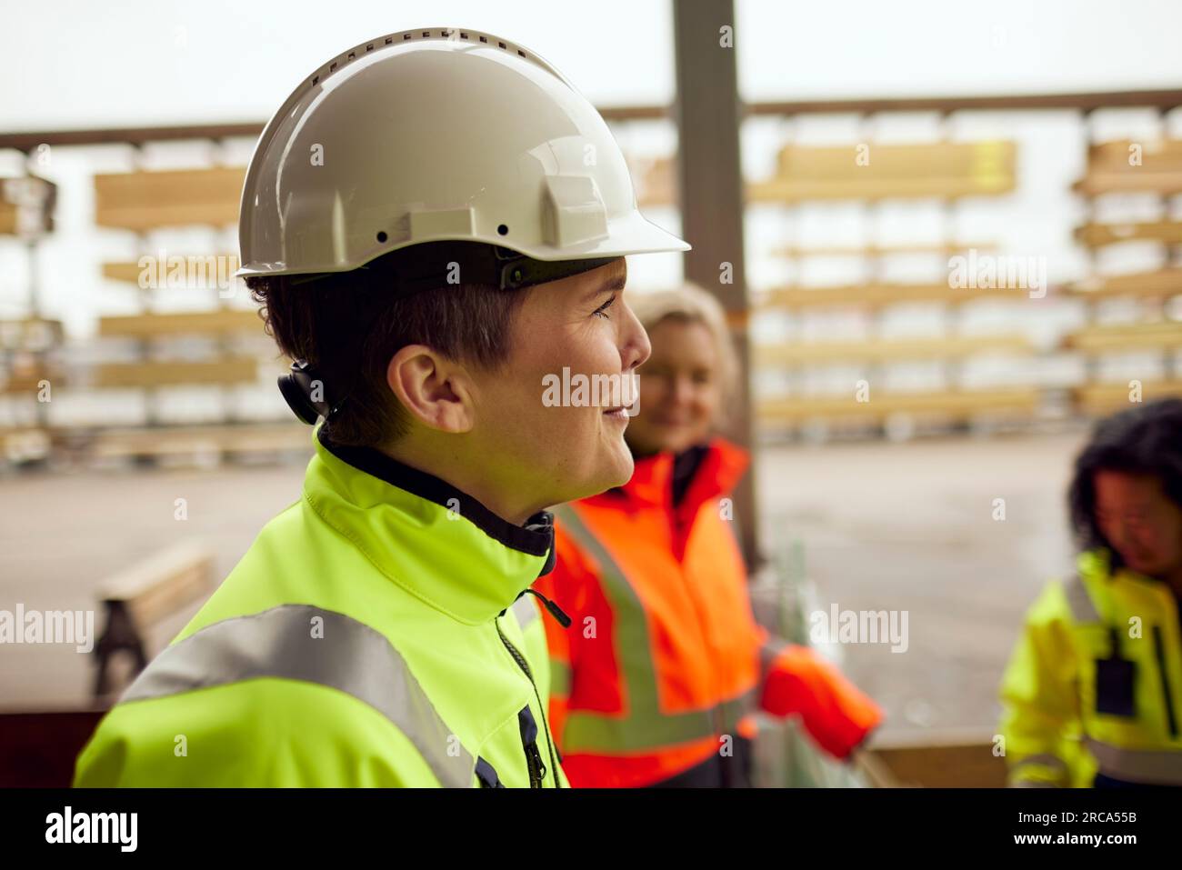 Side view of smiling engineer wearing hardhat at industry Stock Photo ...