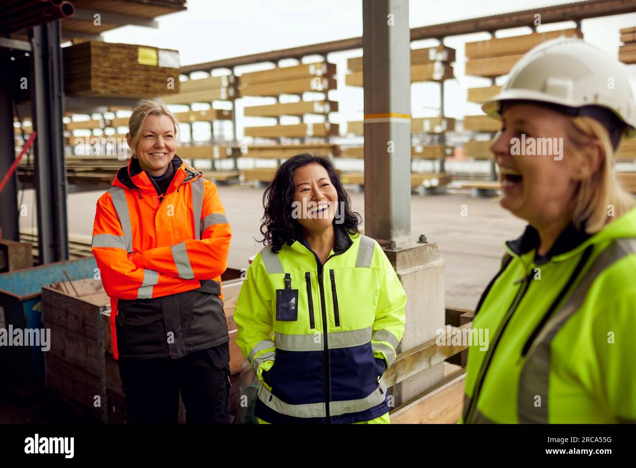 Happy multiracial female workers with colleague at industry Stock Photo ...