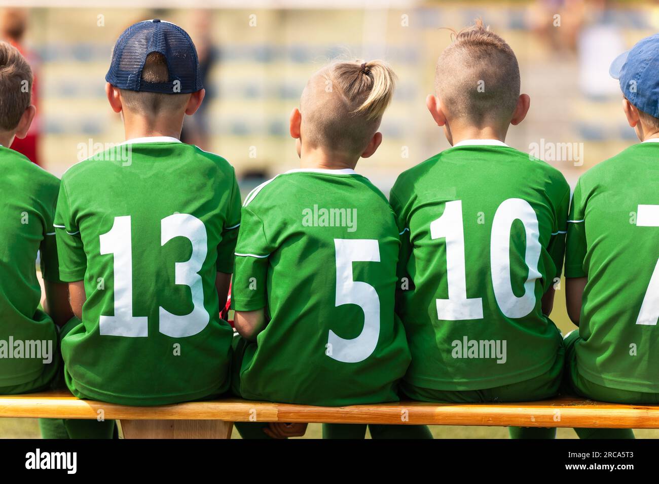 School soccer players sitting on wooden substitute bench. Group of ...