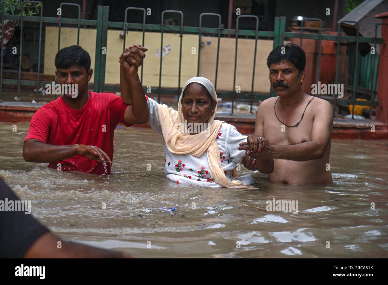 New Delhi, India. 13th July, 2023. People wade through a flooded ...