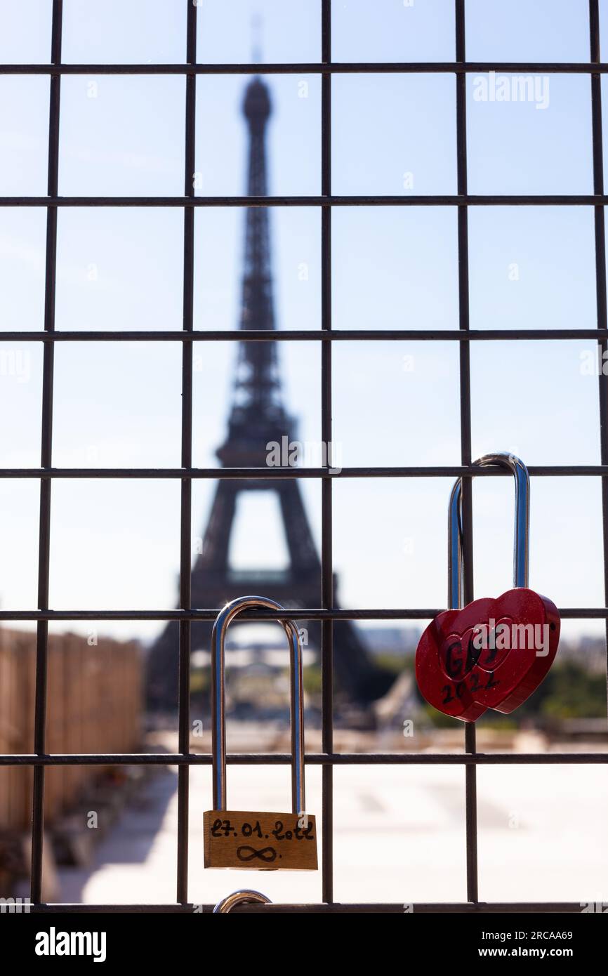 Red love lock on iron grid, with two lovers' names and Eiffel Tower on ...