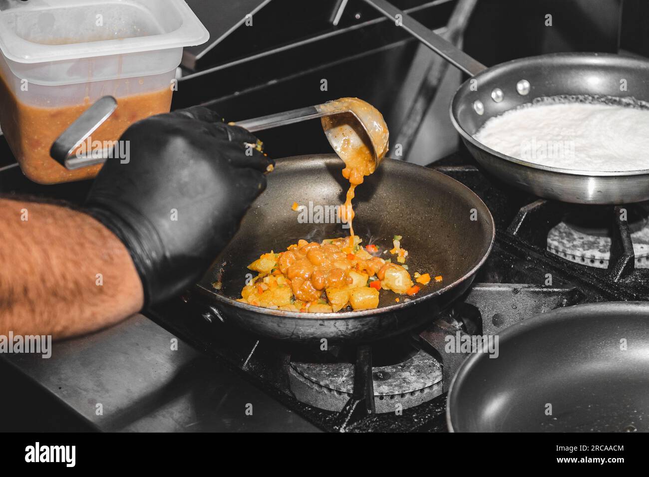 Cooking pan with risotto food on a stove pouring a salse Stock Photo ...
