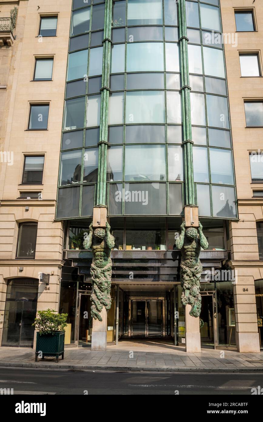 Traditional caryatids supporting a modern glass building, Avenue ...
