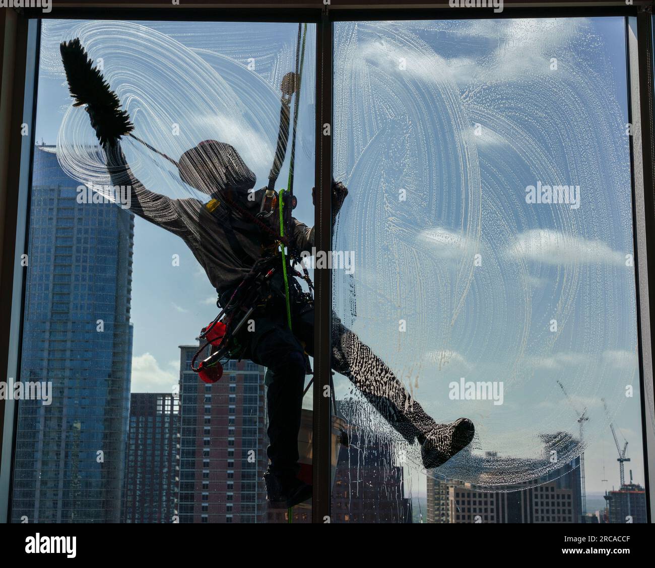 Window washer high up with Austin Texas skyline behind Stock Photo - Alamy