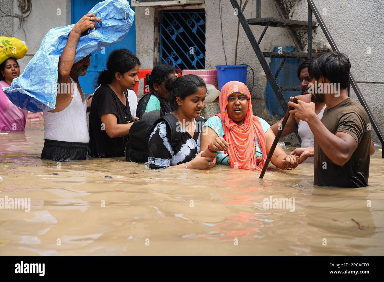 New Delhi, India. 13th July, 2023. People wade through a flooded ...