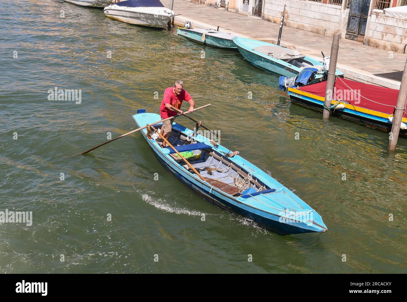 High-angle view of a senior man standing rowing in Venetian row style ...