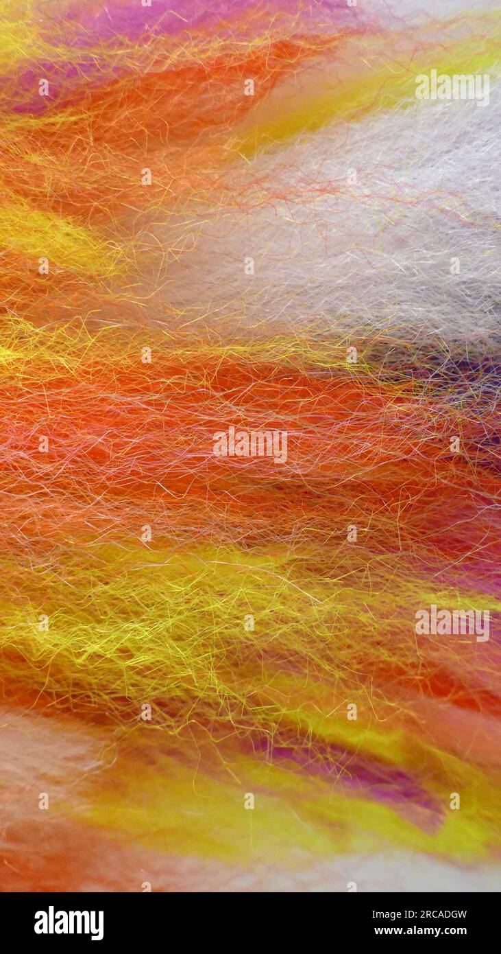 Vertical picture of fluffy wool-like threads in the colours orange ...