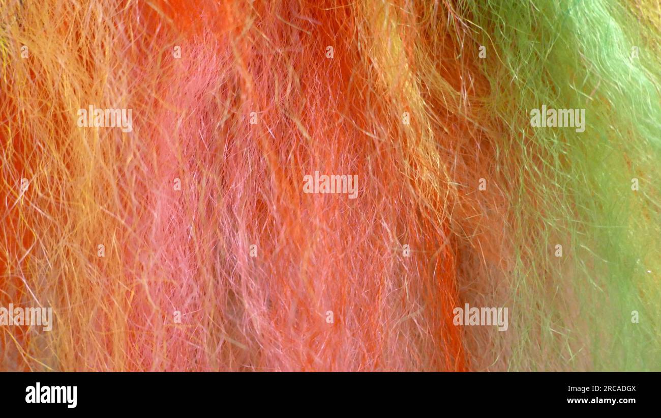 Horizontal picture of fluffy wool-like threads in the colours orange ...