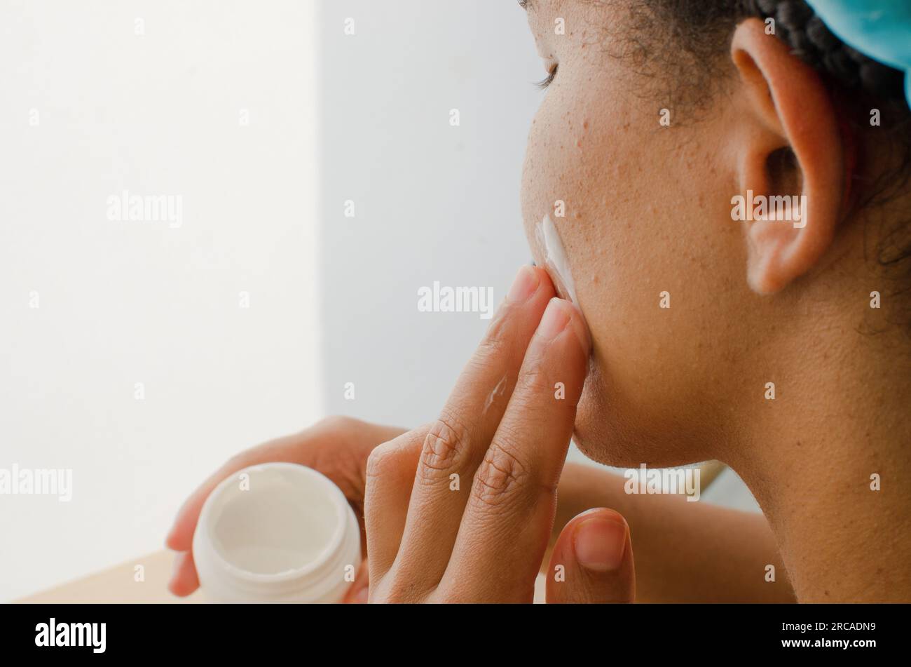 Gentle touch, hands massaging the face with moisturizing cream ...