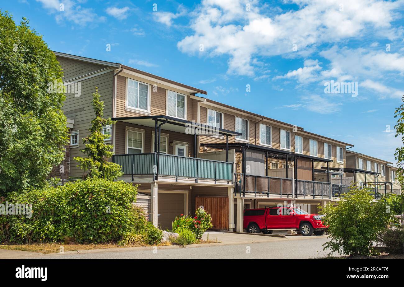 Nice neighborhood on a sunny day. Row of garage doors at parking area ...