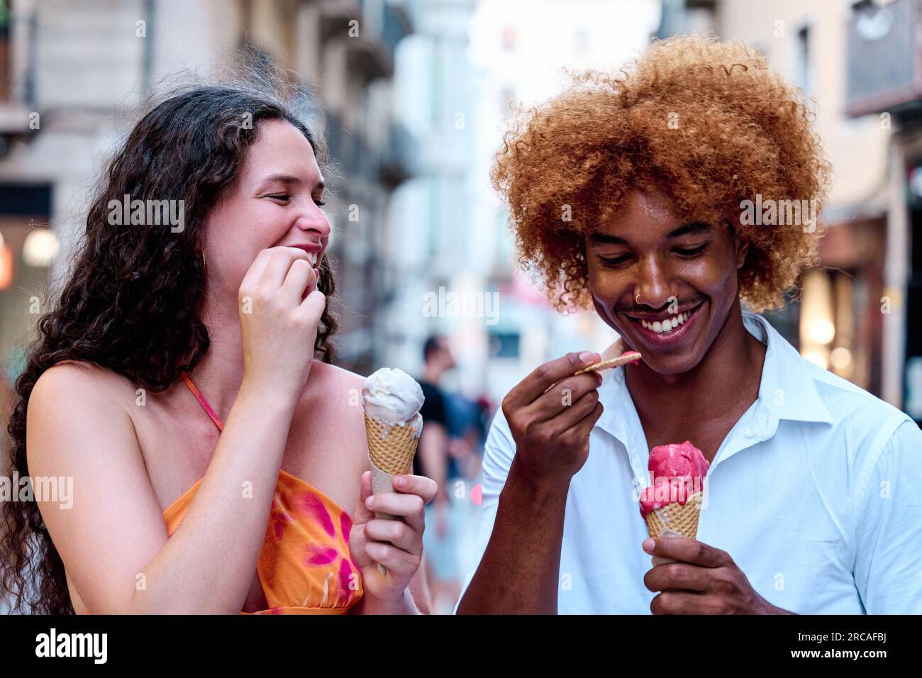 multiethnic couple in love eating ice cream in Barcelona, Spain Stock ...