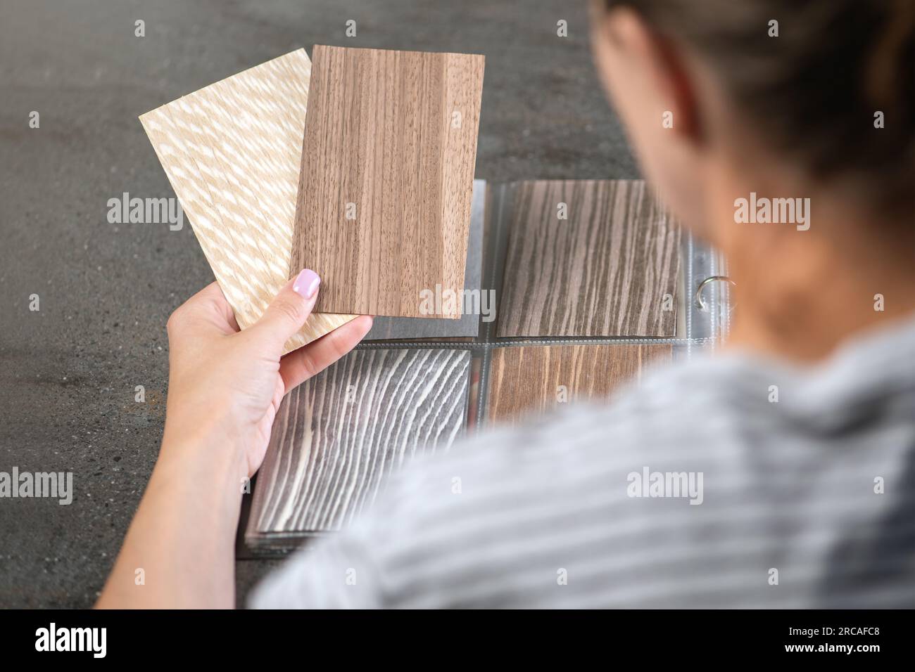 A woman holds samples of different shades for the floor in her hands ...