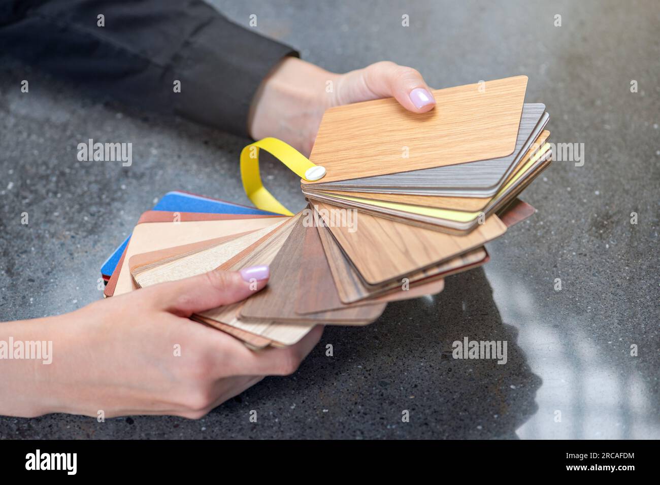 Samples of laminate imitating wood. Woman designer chooses samples of ...