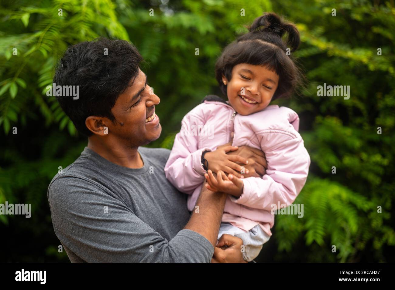 A loving Indian father and his daughter are smiling and enjoying a day ...