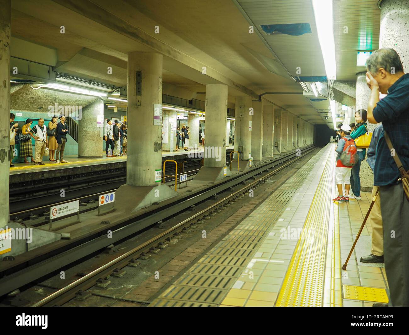 old Japanese man waiting for train coming at underground metro Stock ...