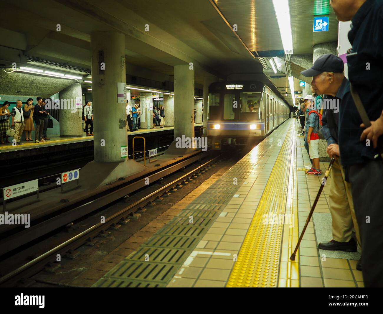 old Japanese man waiting for train coming at underground metro Stock ...