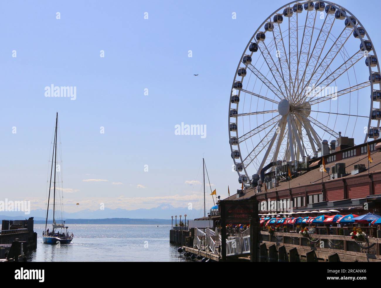 Seattle Great Wheel Ferris wheel built over water with a tour yacht ...