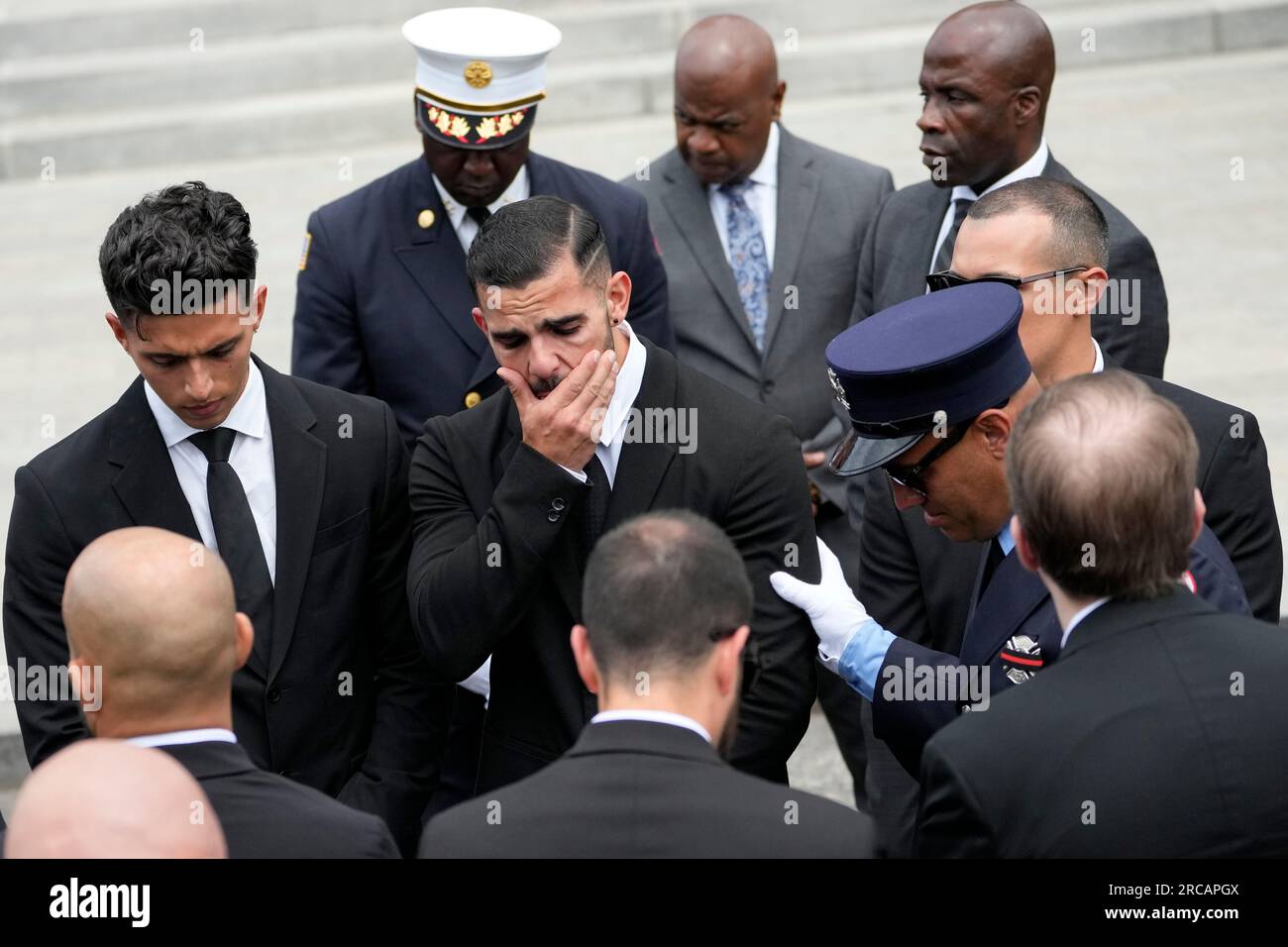 Family members and close friends pause at the firetruck hearse after ...