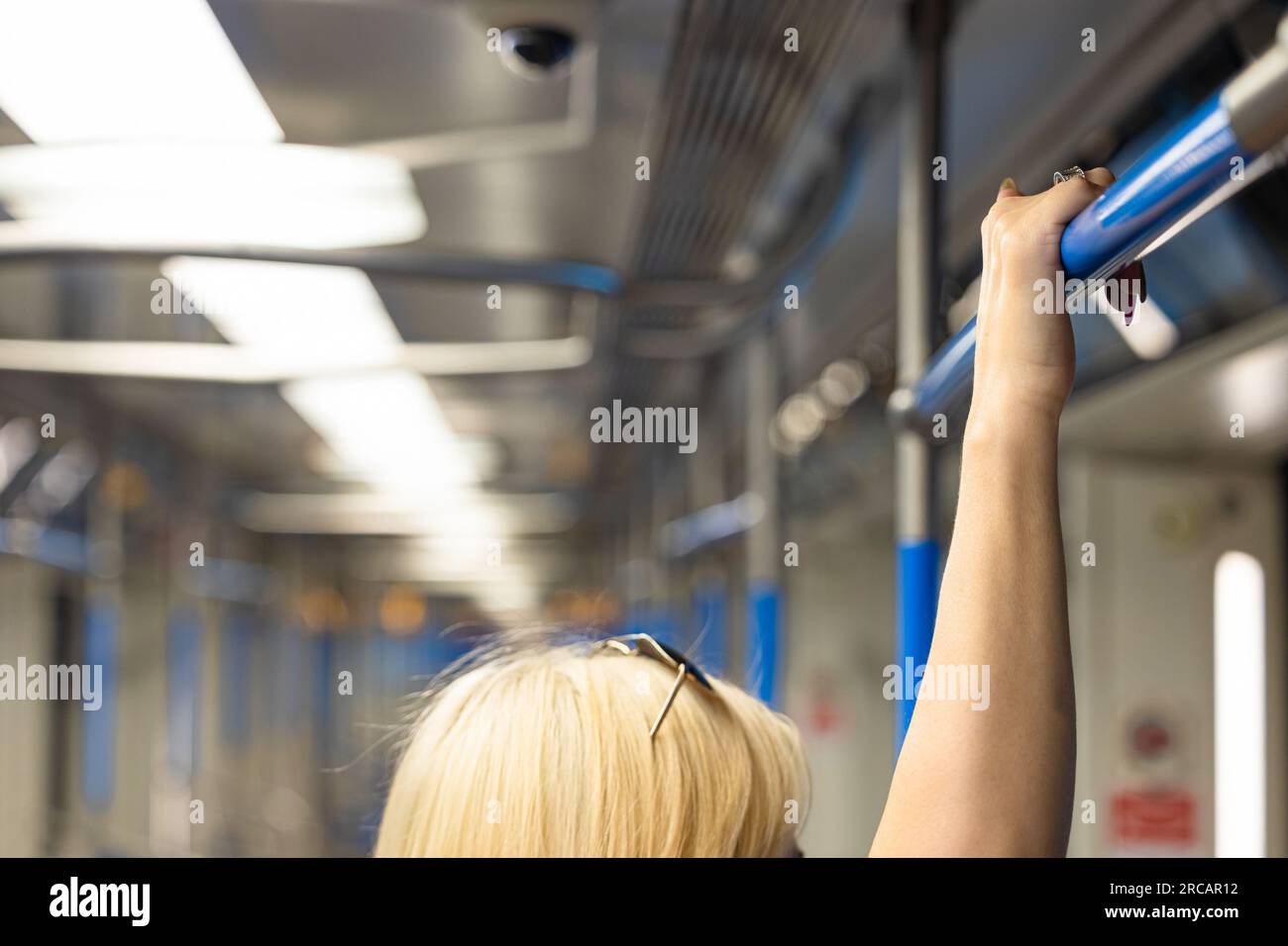 Woman holding hand on handrail in subway car. hand holding the railing ...