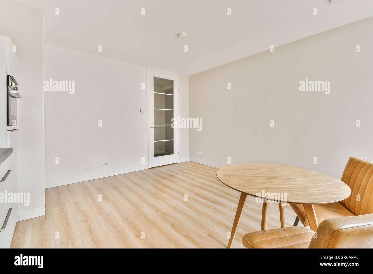 an empty living room with white walls and wood flooring, including a ...