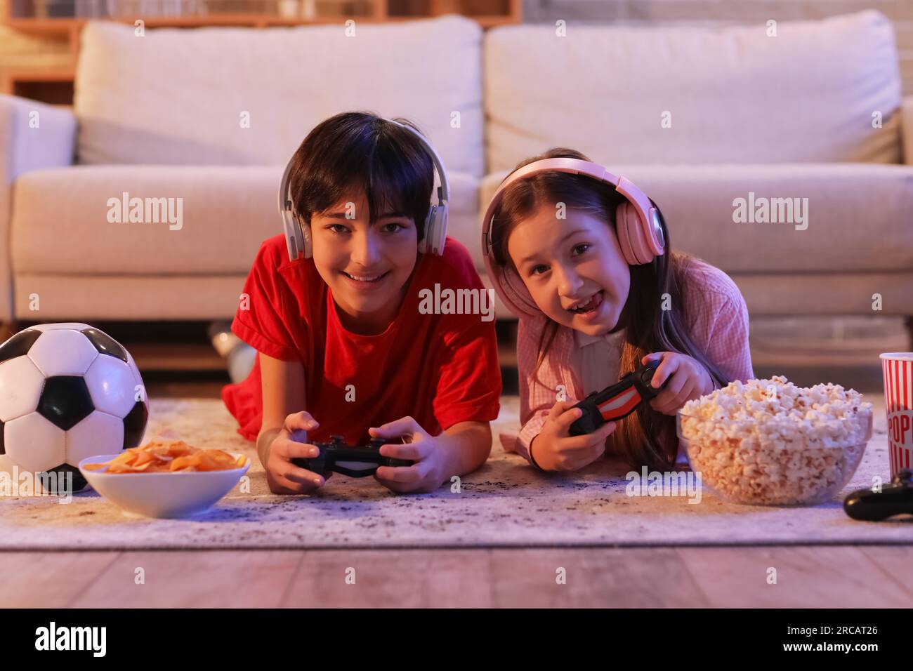 Little children playing video game at home in evening Stock Photo - Alamy