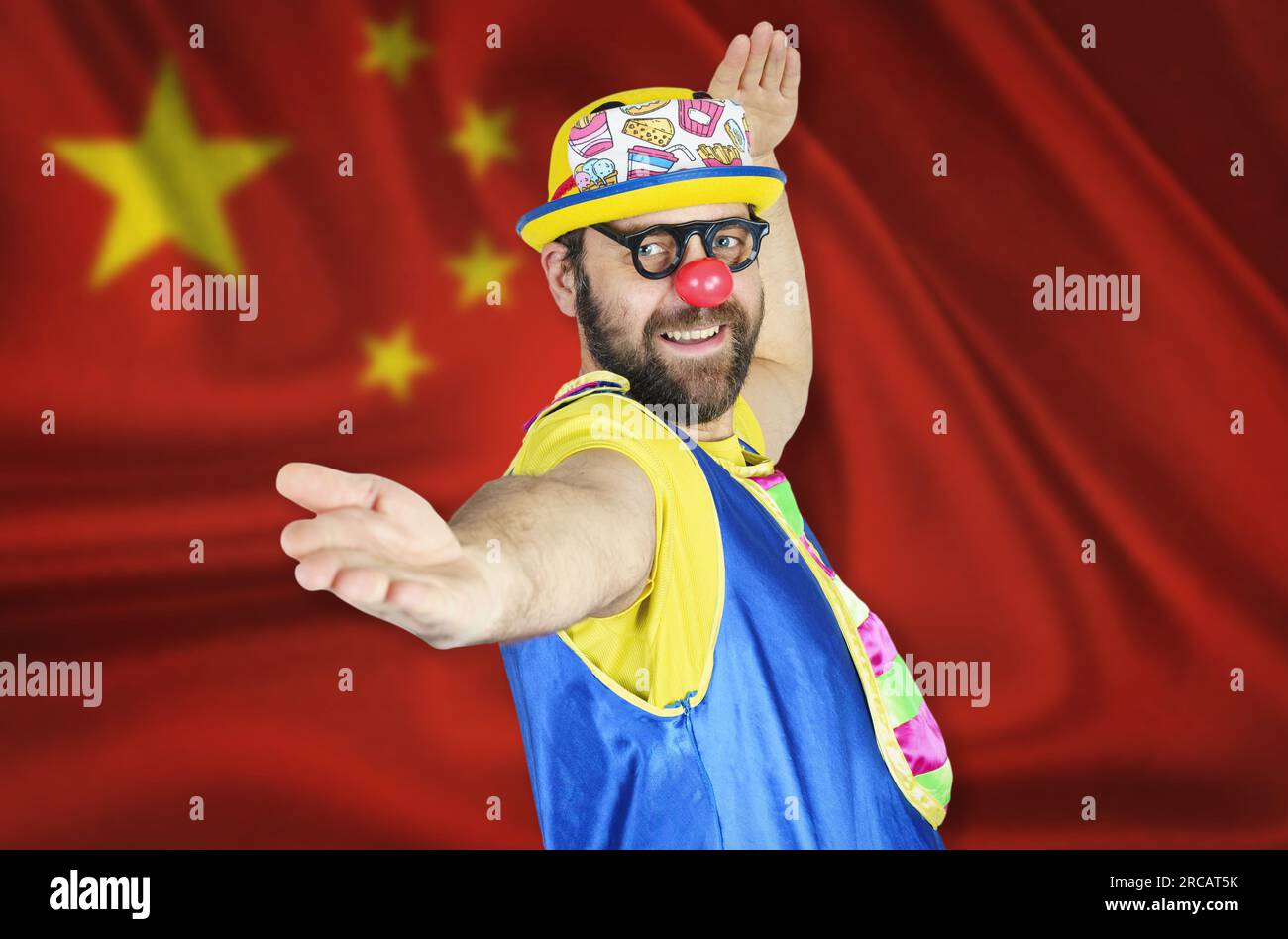 A cheerful clown stands in a welcoming pose against the background of ...