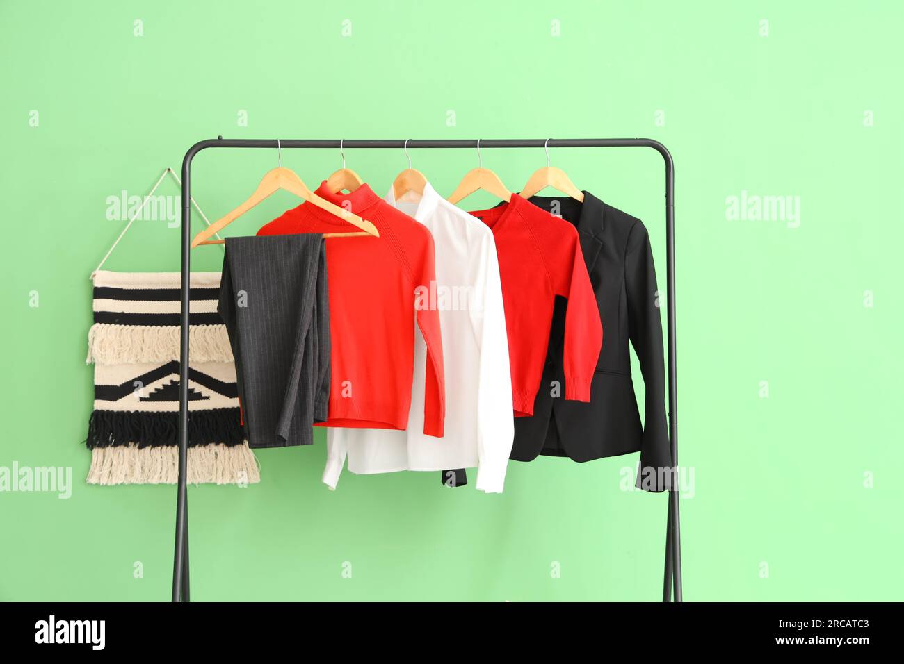 Stylish school uniform hanging on rack near green wall in room Stock ...