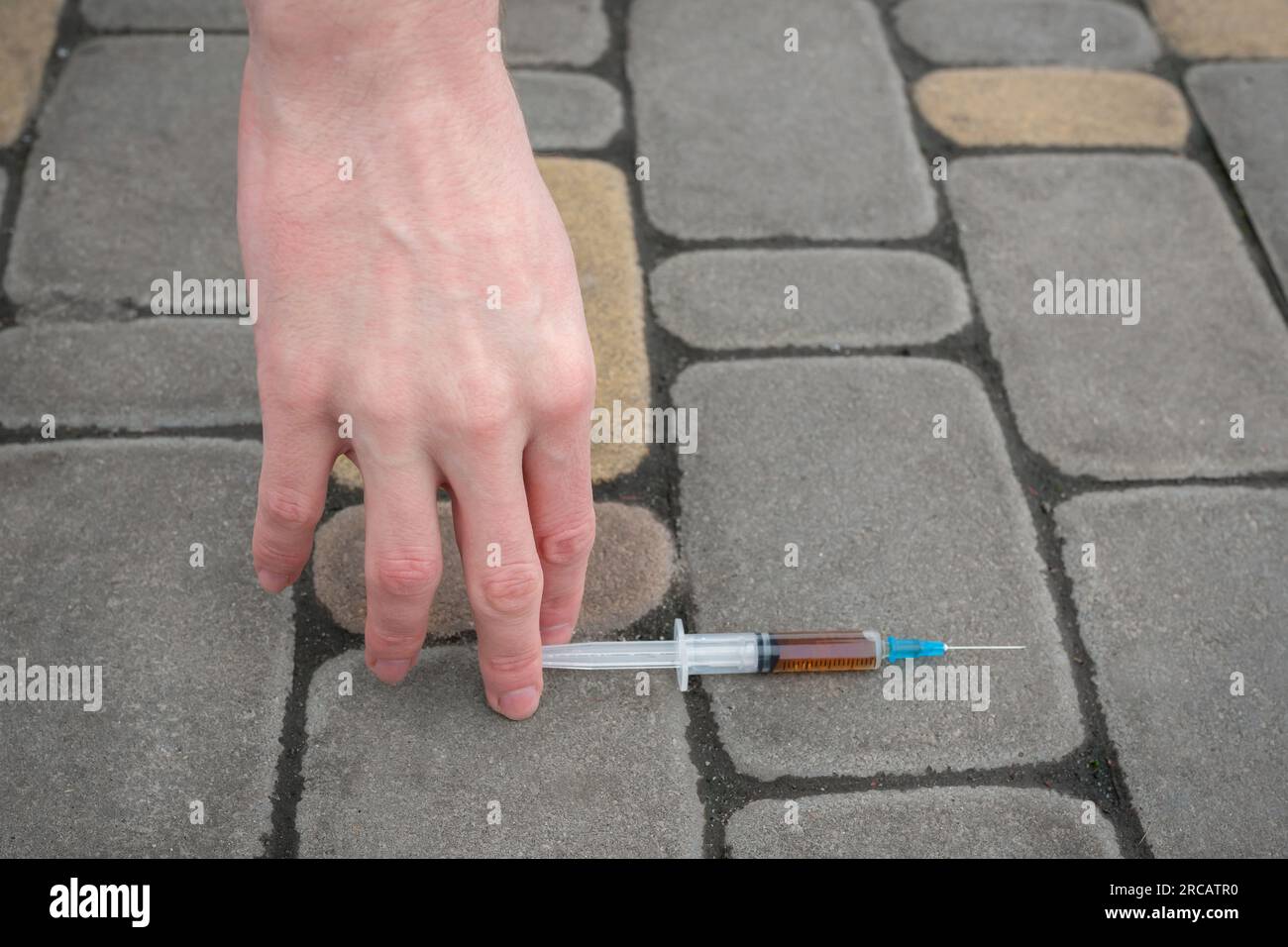 The addicts hand reaches for a syringe. The concept of addiction and ...