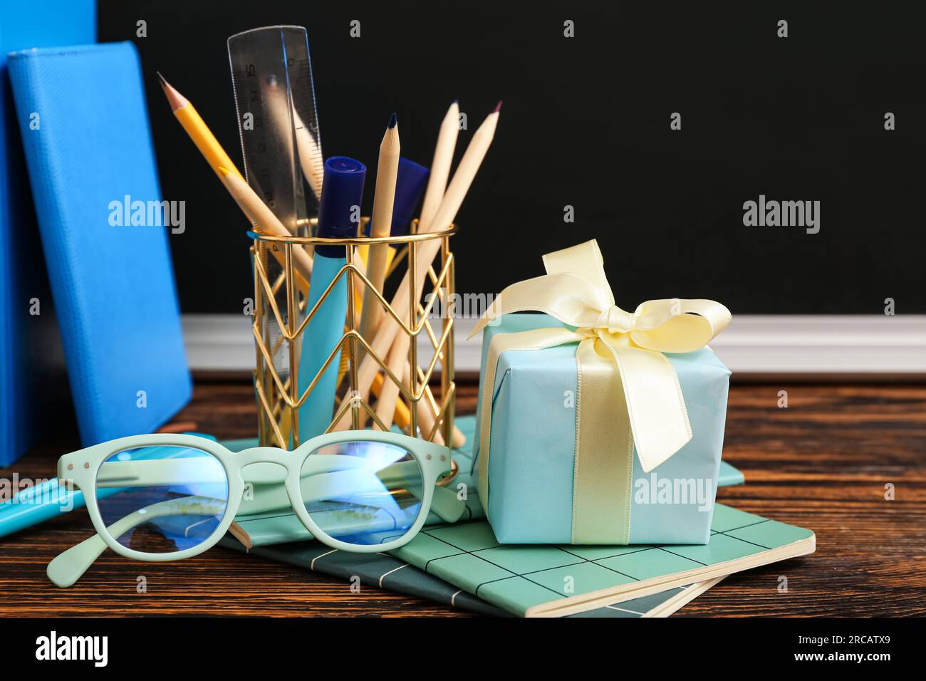 Gift box with eyeglasses, books and different stationery on table in ...