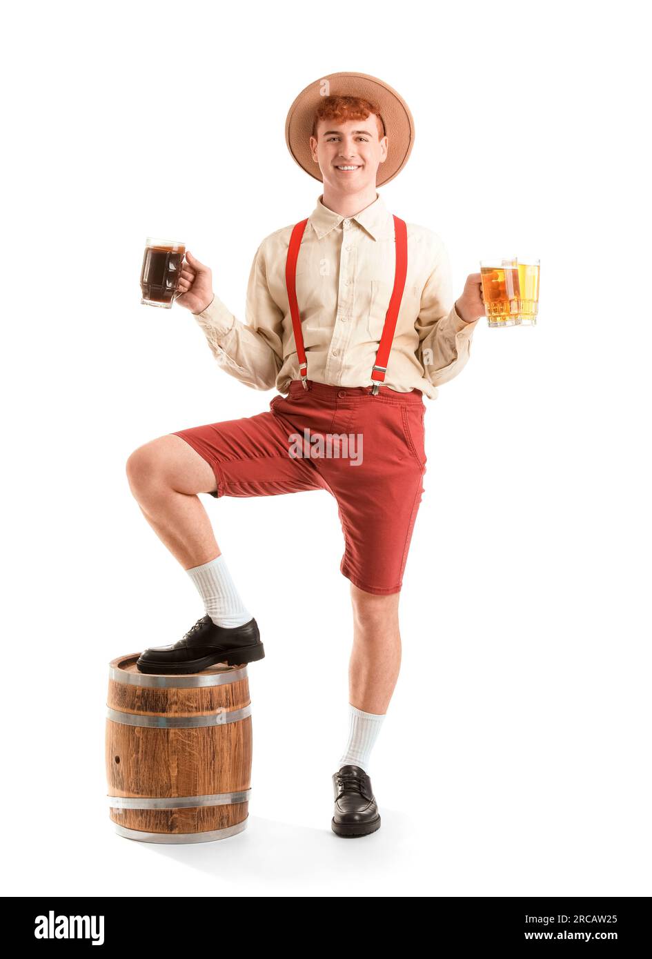 Young man in traditional German clothes with beer on white background ...