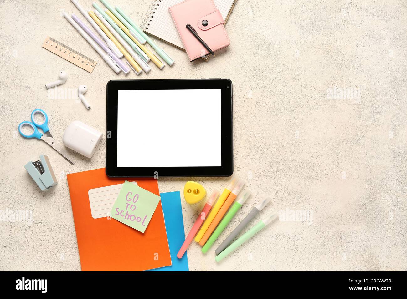 Sticky note with text GO TO SCHOOL, tablet and different stationery on ...