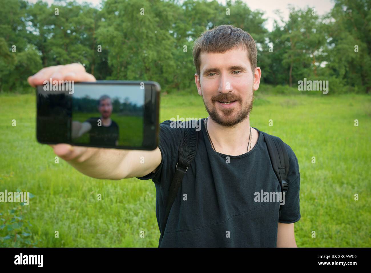 Blogging concept, a male blogger takes pictures of himself in the ...