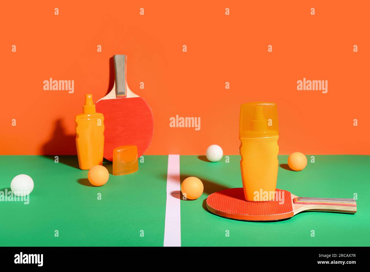 Bottles of sunscreen cream, ping pong rackets and balls on color ...